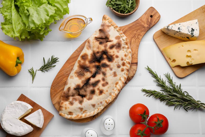 Tasty Pizza Calzone with Cheese and Different Products on White Tiled ...