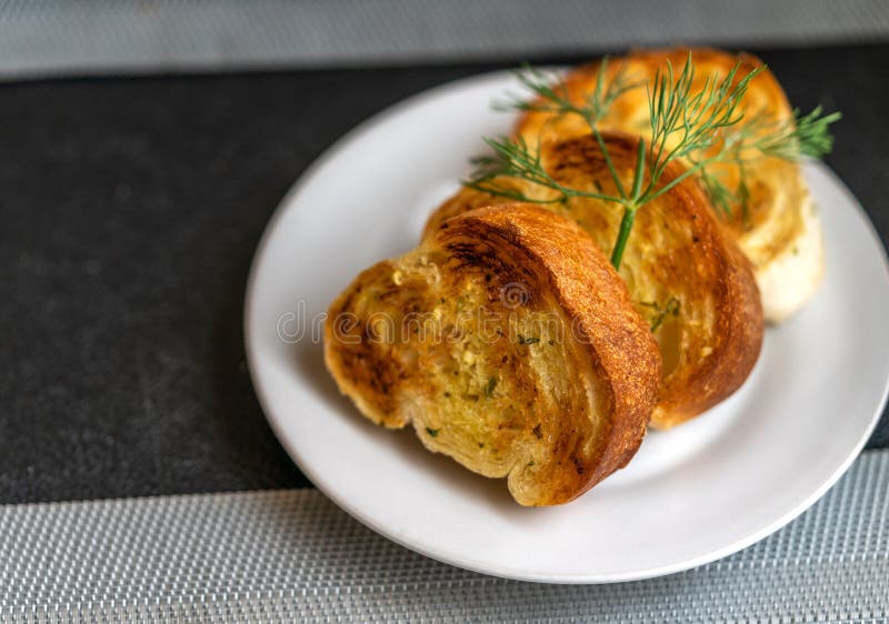 Tasty Sliced Bread with Garlic on a White Plate on a Table in a ...
