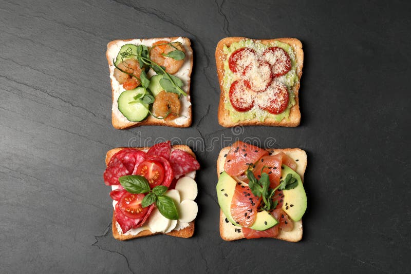 Tasty Toasts with Different Toppings on Black Table, Flat Lay Stock ...