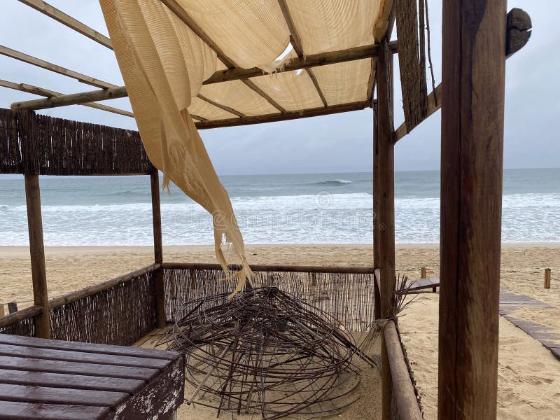 Tattered Canopy Flutters in the Wind, Empty Beach with Gentle Ocean ...