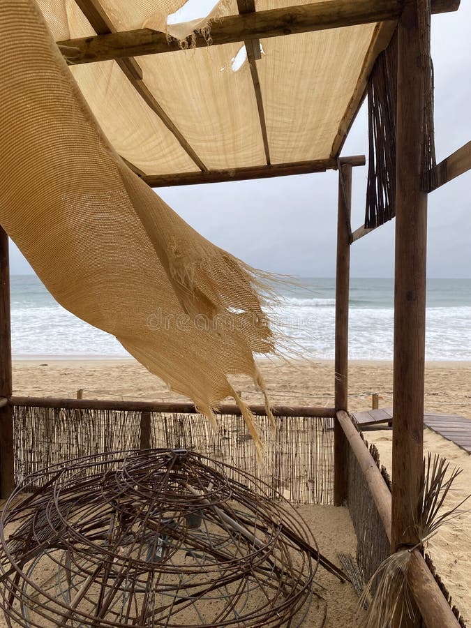 Tattered Canopy Flutters in the Wind, Empty Beach with Gentle Ocean ...