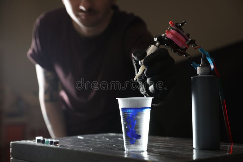 Tattoo Artist Cleaning Machine Needle at Table, Closeup Stock Photo ...