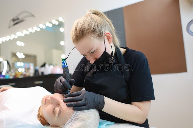 Tattoo Artist is in His Office and Performs the Permanent Make-up ...
