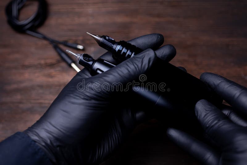 A Tattoo Artist Holds Two Tattoo Machines in His Hands Stock Image ...