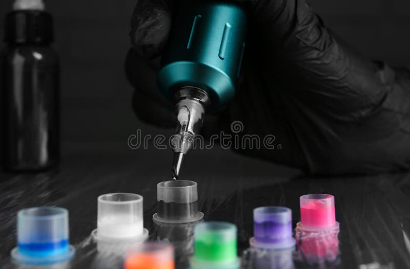 Tattoo Artist with Professional Machine and Colorful Inks at Table ...