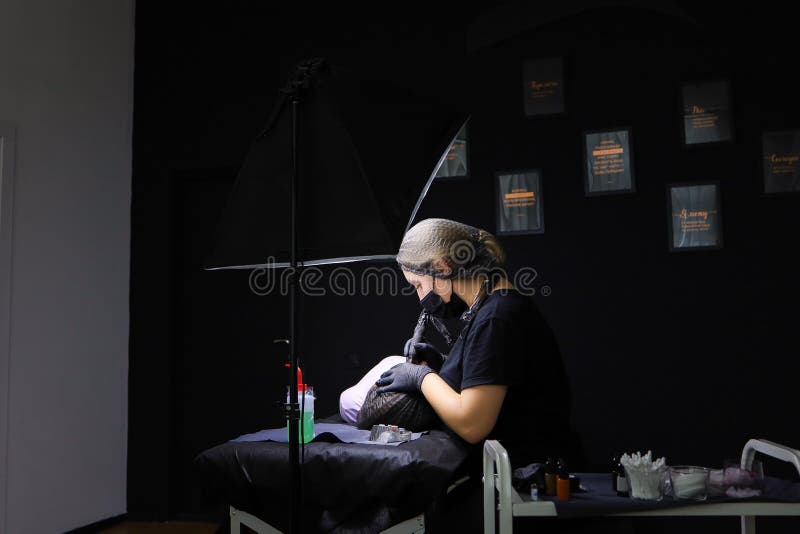 Tattoo Artist Sits in a Cosmetology Office Working with a Client Stock ...