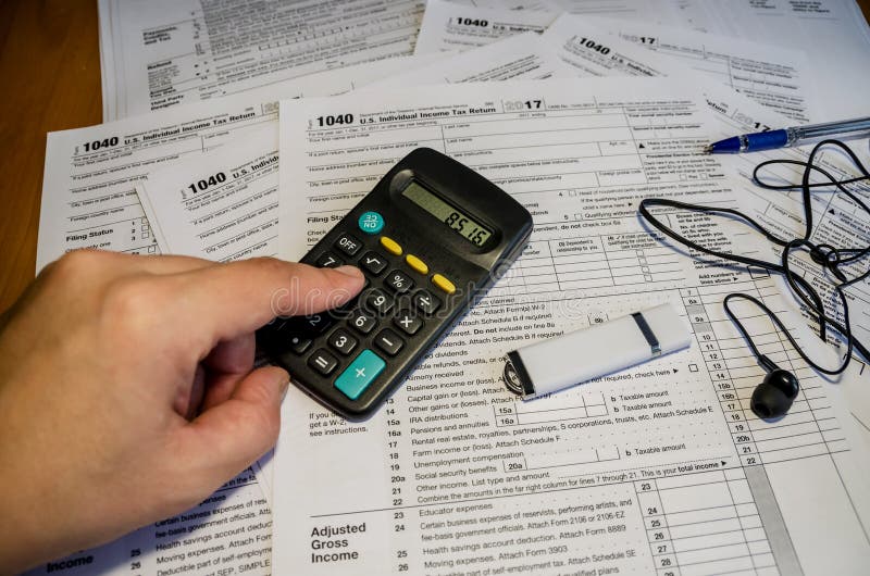 A Hand that Counts on a Calculator. Tax Forms 1040 Editorial Stock ...