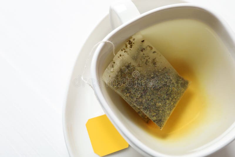 Tea Bag in Cup with Water on White Table, Top View. Space for Text ...