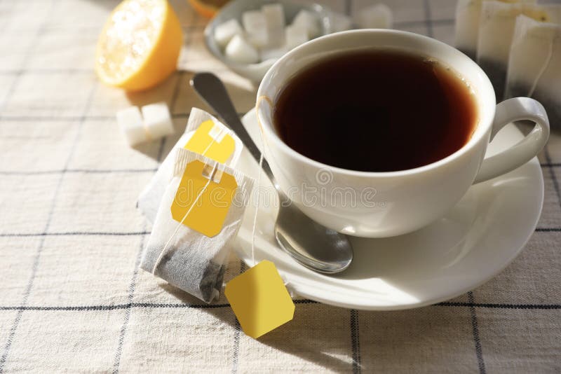 Tea Bags Near Cup of Hot Drink on Table, Closeup Stock Photo - Image of ...