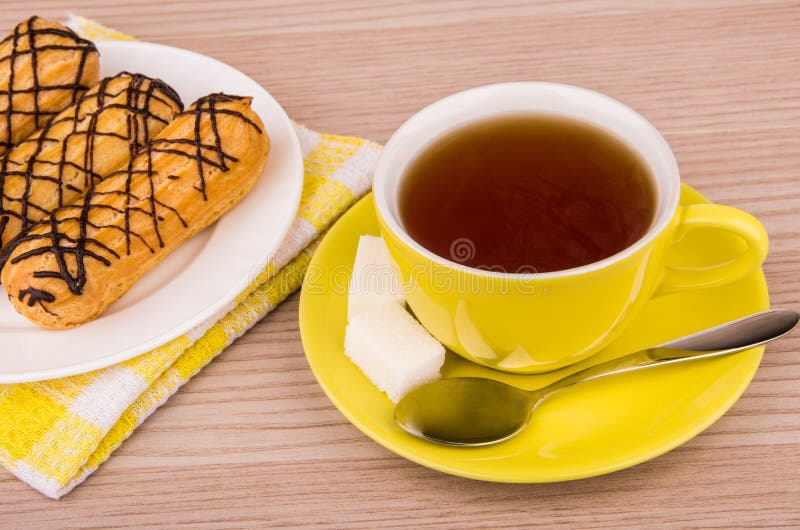 Tea in Cup, Sugar and Eclairs on Wooden Table Stock Photo - Image of ...
