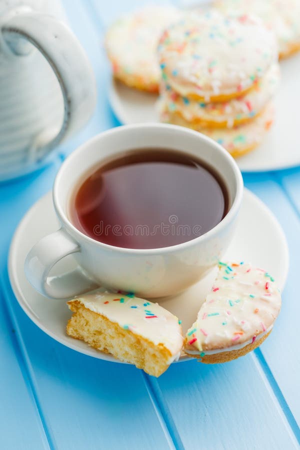 Tea Cup and Sweet Dessert with Sugar Coating on Blue Table Stock Image ...