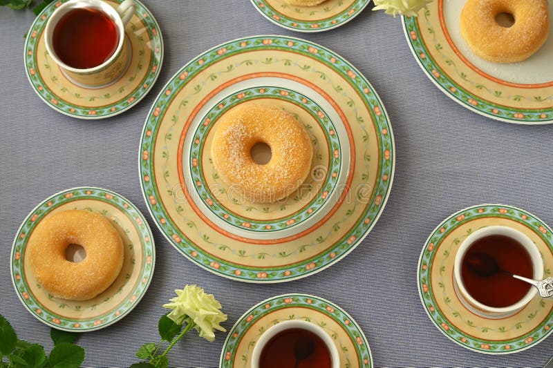 Tea and Donuts Table Setting with Beautiful Tea Service and Flowers ...