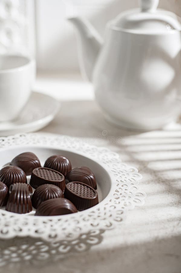 Tea Drinking. White Teapot with Cups and a Set of Chocolates Stock ...