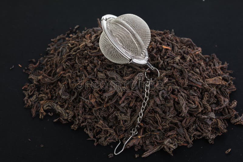 Tea Filter on a Chain with Black Tea on a Pile of Dry Tea Leaves. Tea ...