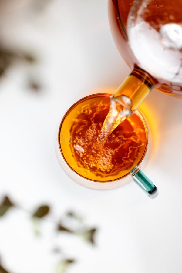 Tea Flowing To a Glass Cup from a Glass Teapot, View from Top Stock ...