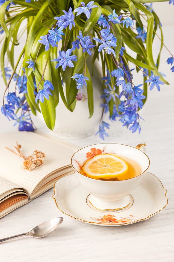 Tea with Lemon and Bouquet of Blue Primroses on the Table Stock Photo ...
