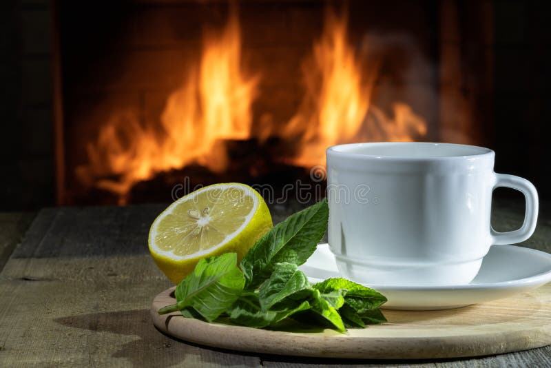 Tea with Lemon and Mint in Front of Burning Fireplace in a Country ...