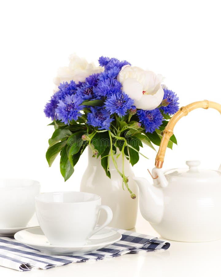 Tea Pot and Cups on Table with Blue and White Bouquet on White B Stock ...