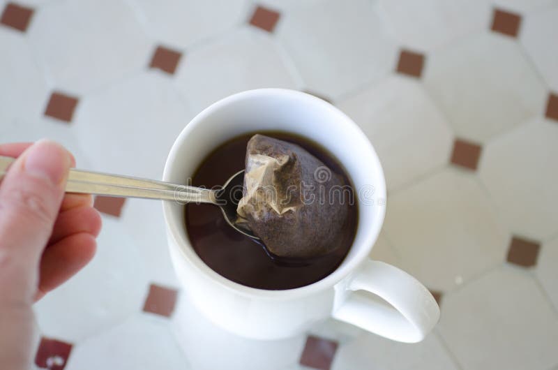 Tea with a tea bag stock photo. Image of spoon, hand - 114958492