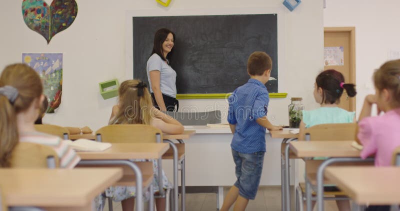 Teacher Asking Her Students a Question at the Elementary School and ...