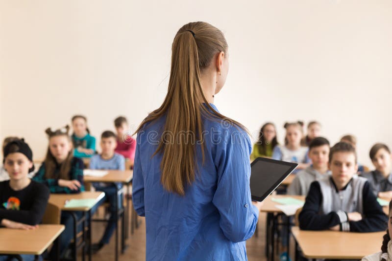 Teacher Asking Her Students a Question at the Elementary School with ...