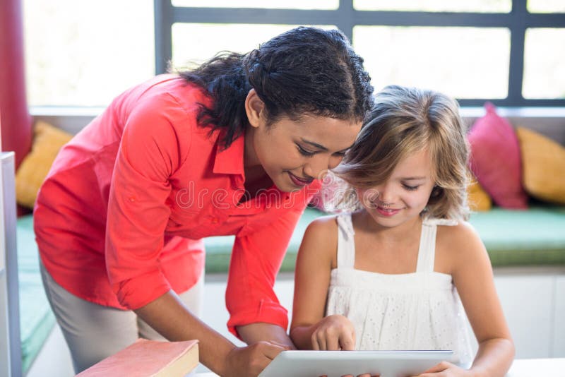 Teacher with Girls Using Digital Tablets in Library Stock Photo - Image ...