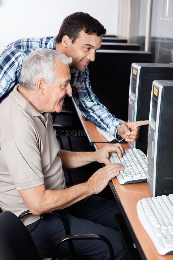 Irritated Teacher with Senior Man Using Computer in Class Stock Photo ...