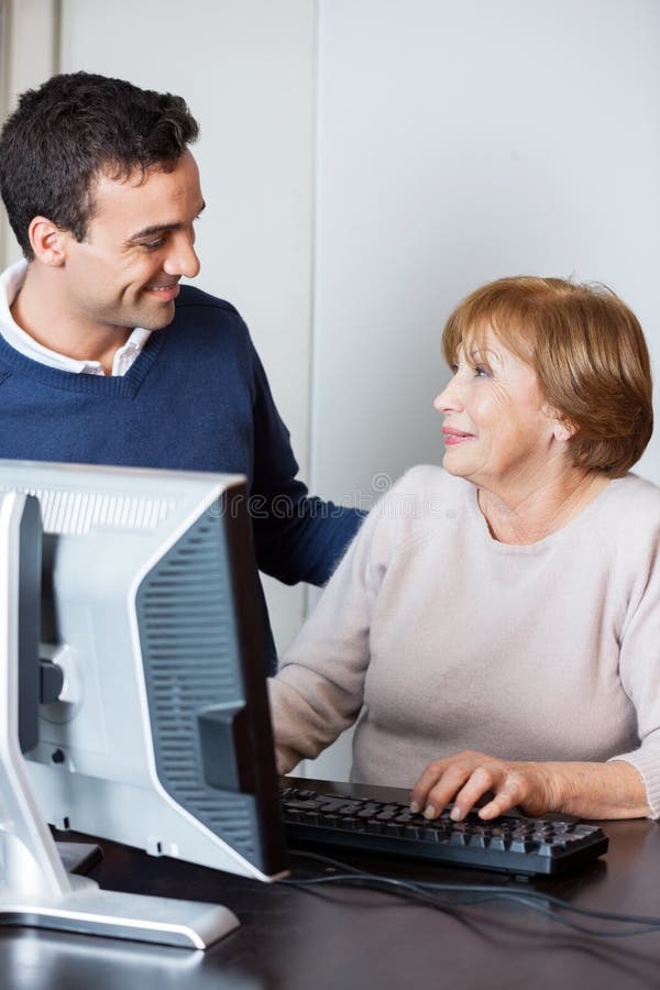 Irritated Teacher with Senior Man Using Computer in Class Stock Photo ...