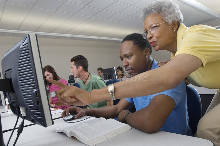 Teacher Assisting Student in Computer Class Stock Photo - Image of ...