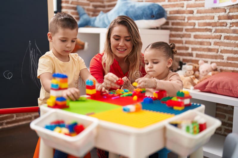 Teacher with Boy and Girl Playing with Construction Blocks Sitting on ...