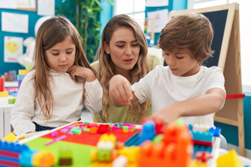 Teacher with Boy and Girl Playing with Construction Blocks Sitting on ...