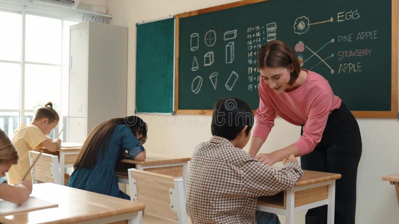 Teacher Checking Cute Student Homework while Explaining Idea at Class ...