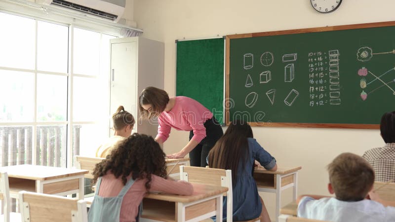 Teacher Checking Cute Student Homework while Explaining Idea at Class ...