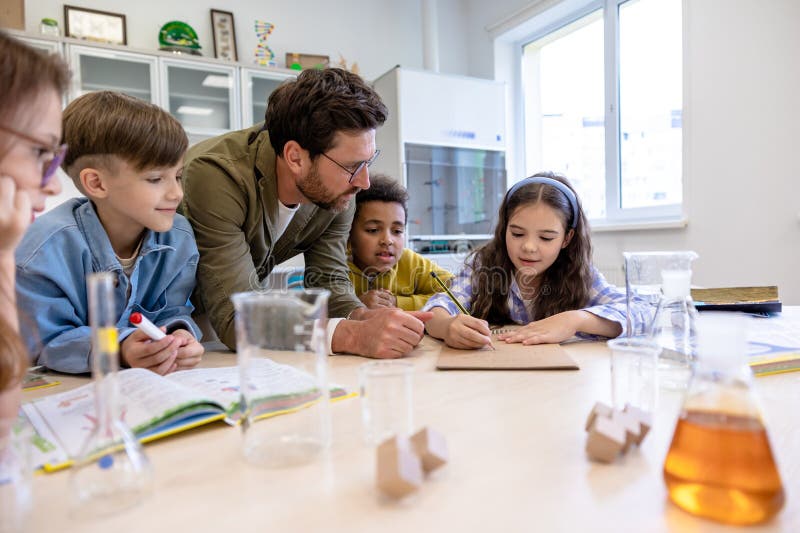 Teacher and Children in a Classroom, Exploring a New Topic in Chemistry ...