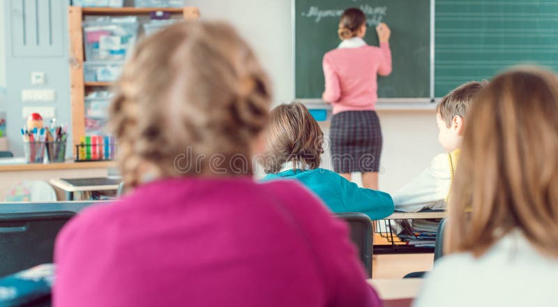 Teacher in Class with Fourth Grade Students in Front of Black Board ...