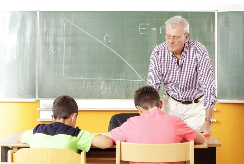 Elementary Classroom Setting Focus On Teacher And Chalkboard Stock