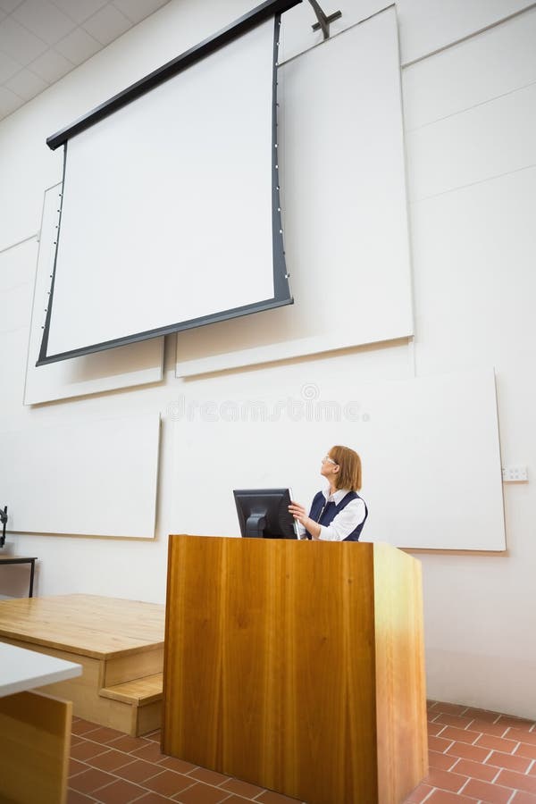 Teacher with Computer and Projection Screen in Lecture Hall Stock Image ...