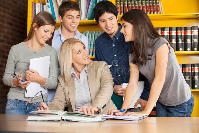 Teacher Discussing with Students at Table in Stock Image - Image of ...
