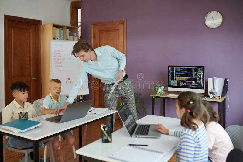 Teacher Engaging Students in Classroom Setting with Laptops Stock Photo ...