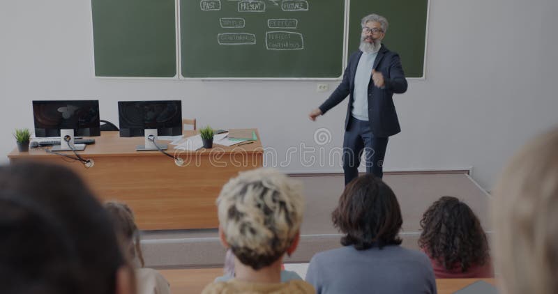 Teacher of English Speaking To Group of Students Pointing at Chalk ...