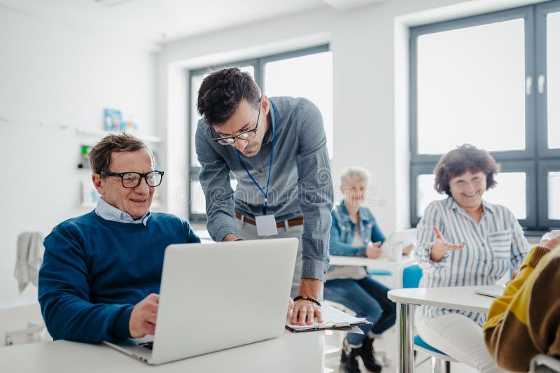 Teacher Explaining Senior Students How To Work with Laptop and Internet ...