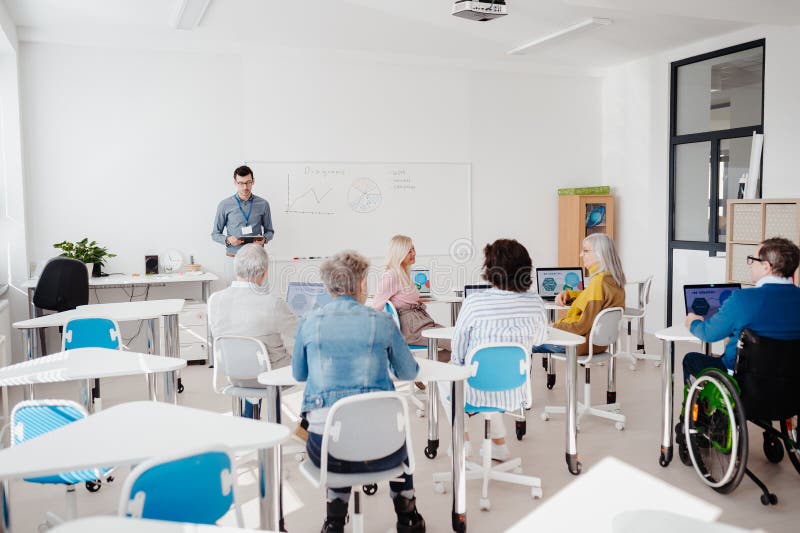 Teacher Explaining Senior Students How To Work with Laptop and Internet ...