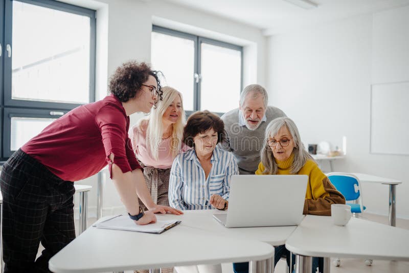 Teacher Explaining Senior Students How To Work with Laptop ...