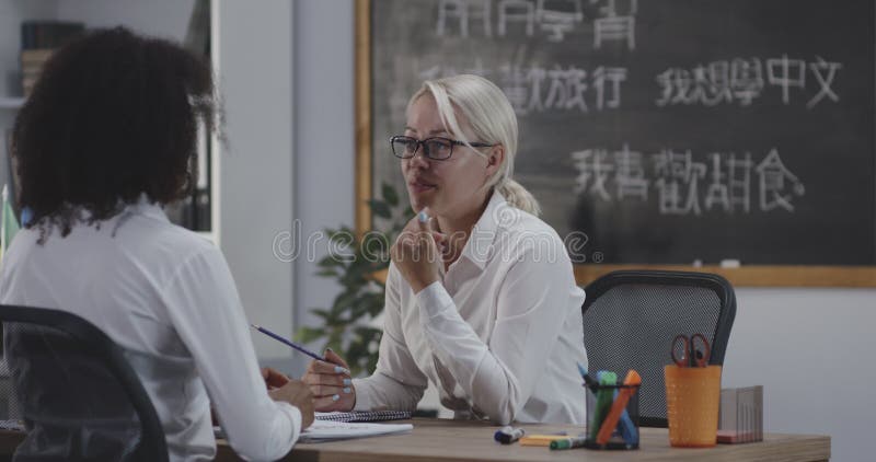 Teacher Explaining To Student in the Classroom Stock Video - Video of ...