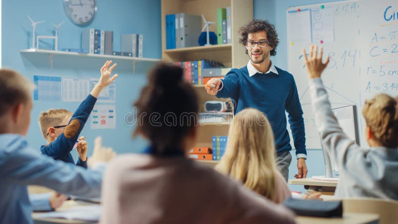 Teacher Explains Lesson To a Diverse Classroom of Bright Children. in ...