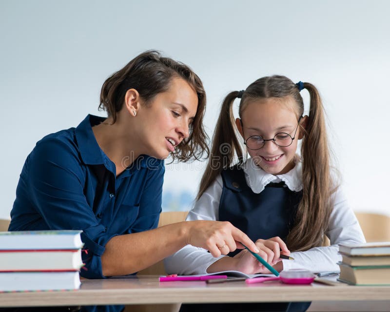 The Teacher Explains the Task To the Schoolgirl in the Classroom. Stock ...