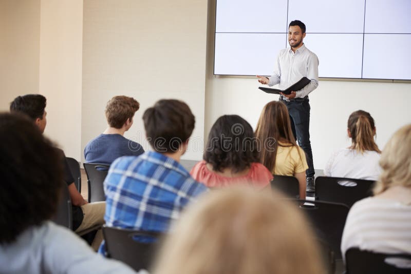 Teacher Giving Presentation To High School Class in Front of Screen ...