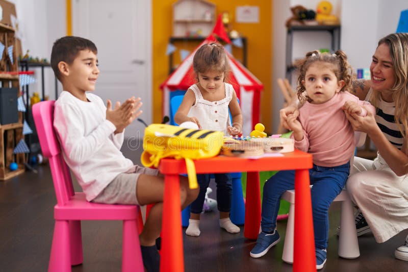 Teacher and Group of Kids Sitting on Table Applauding at Kindergarten ...