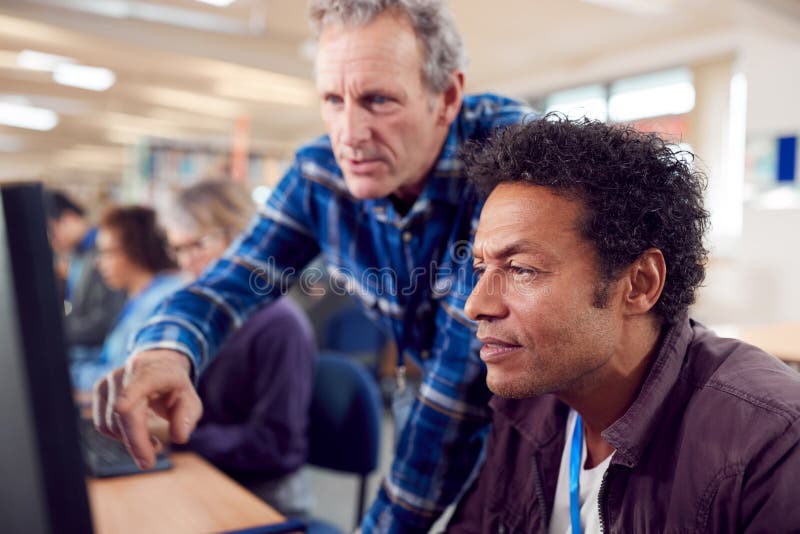 Teacher with Group of Mature Adult Students in Class Working at ...
