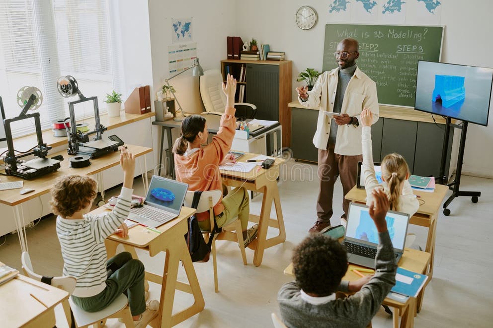Teacher Guiding Students in Classroom with Computers Stock Image ...